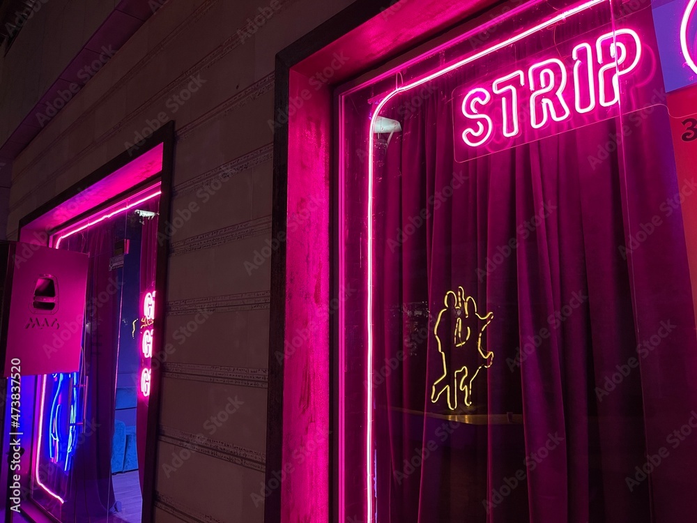Pink neon sign of a strip club glowing Stock Photo | Adobe Stock