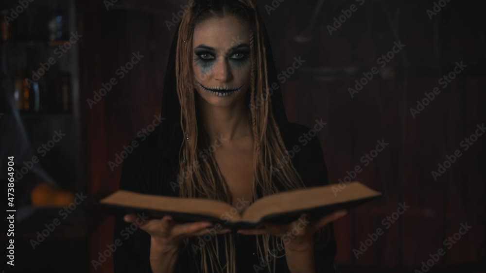 Halloween concept. Witch dressed black hood with dreadlocks standing ...