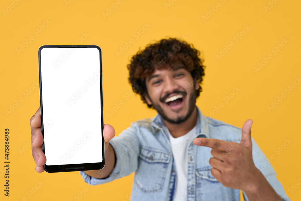 Happy excited young indian man showing smartphone pointing at big ...