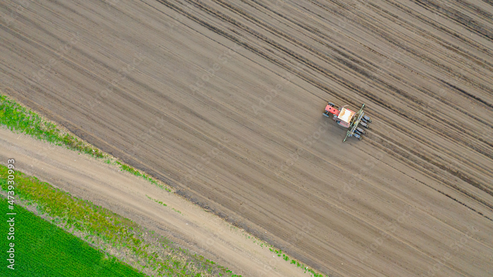 Aerial top view of tractor as dragging a sowing machine over ...