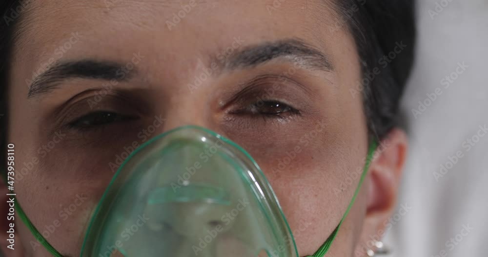 Extreme close-up of a young brunette woman opening her eyes in a ...