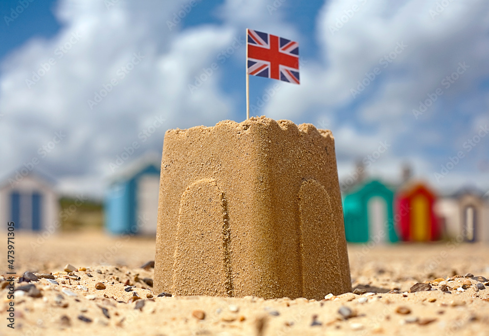 Sandcastle with Union Jack flag on beach during sunny day Stock Photo ...