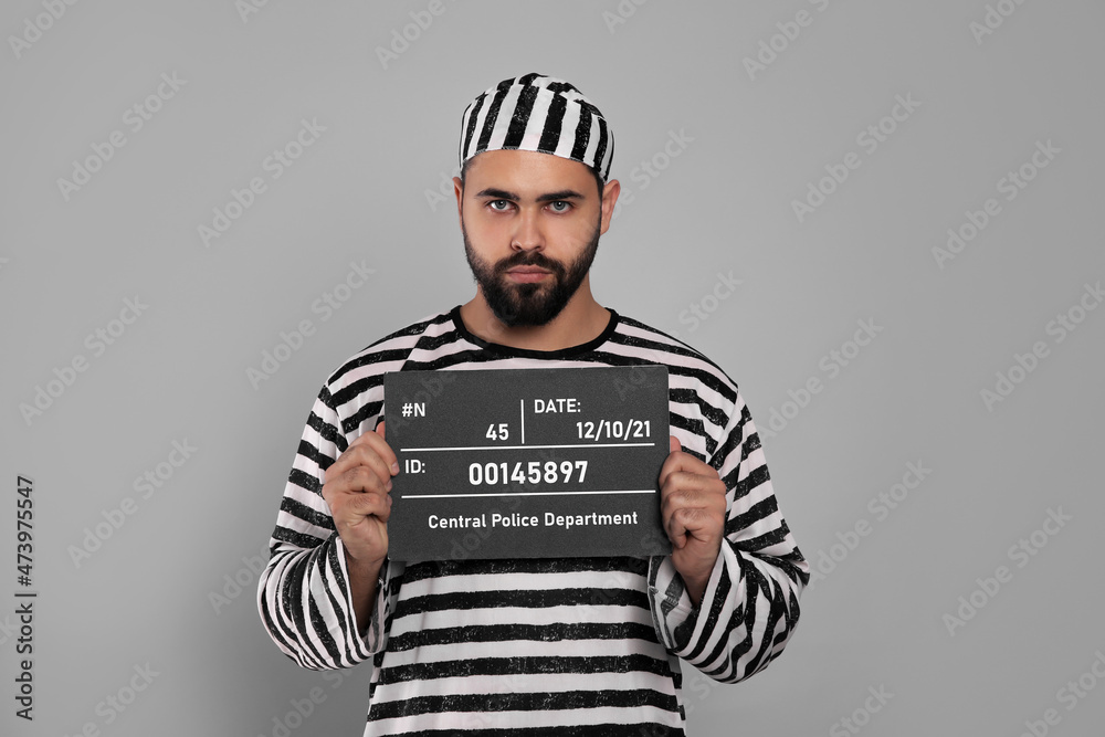 Prisoner in special uniform with mugshot letter board Stock Photo ...