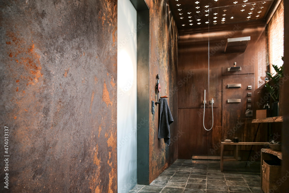 Modern bathroom with corten steel wall cladding and ceiling light ...