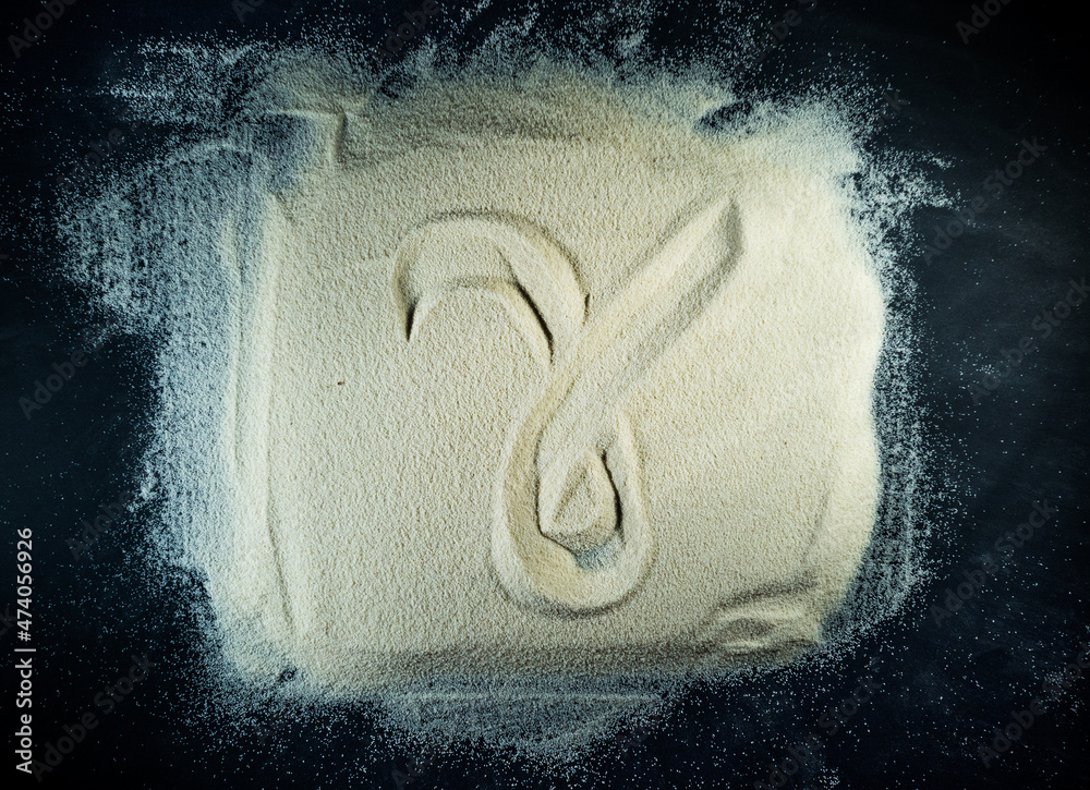Greek letter gamma written on the white sand with black background ...