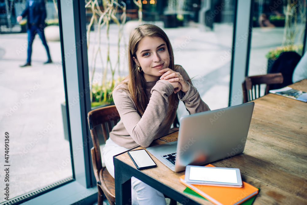 Smiling lady sitting at table with laptop and working Stock Photo ...
