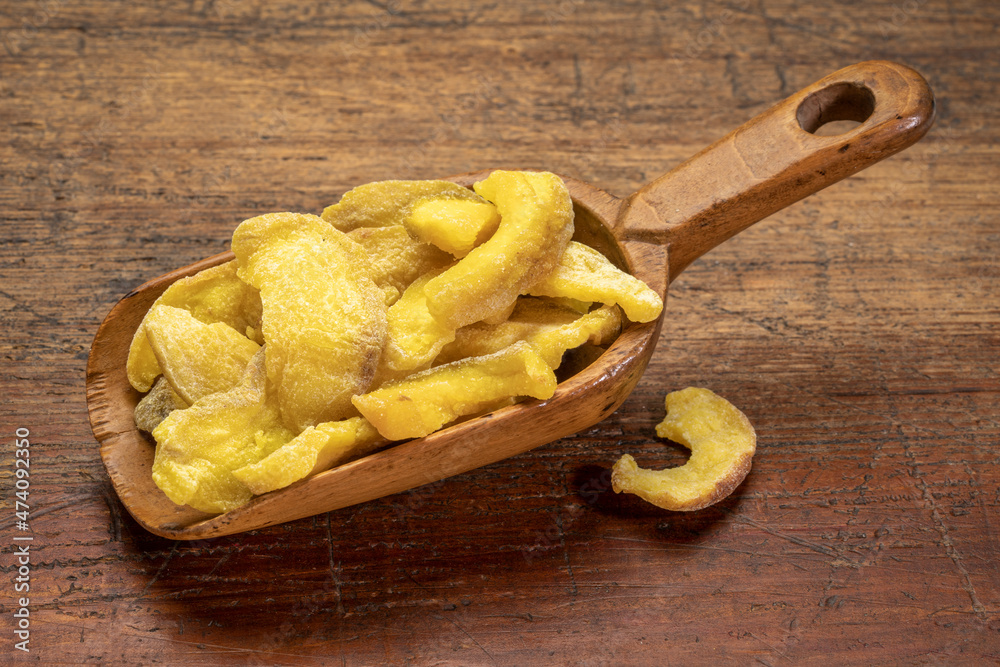 dried guava fruit on a vintage wooden scoop against weathered wood ...