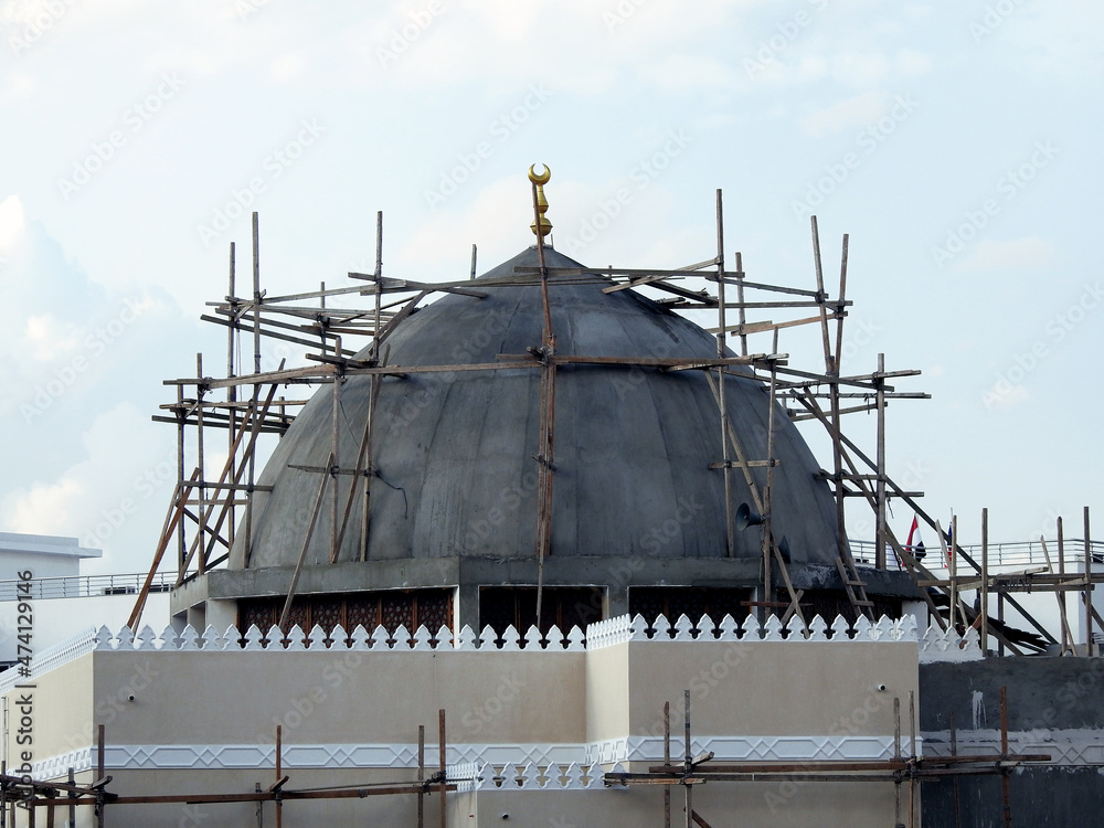 A new mosque under construction against the sunny blue sky, building a ...