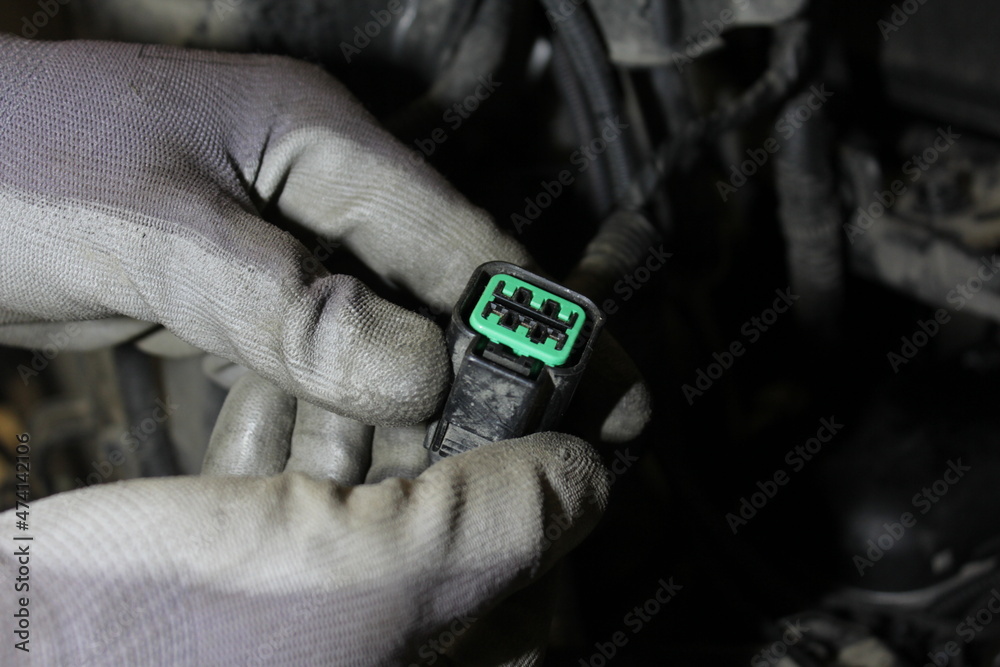 Close-up of the hands of an auto mechanic engaged in car maintenance ...