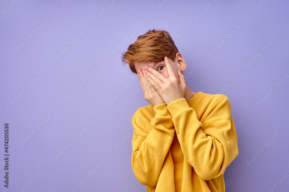 Portrait of scared caucasian teen boy, isolated on purple studio ...