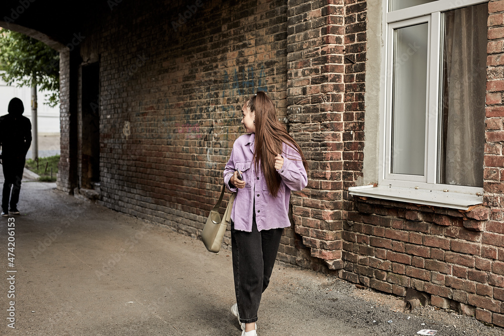 Frightened female is running alone at day time on street. Action. Woman ...