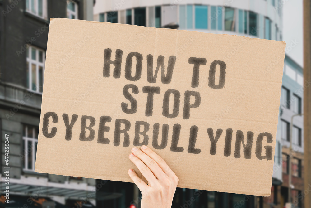 The phrase " How to Stop Cyberbullying " on a banner in men's hand with ...