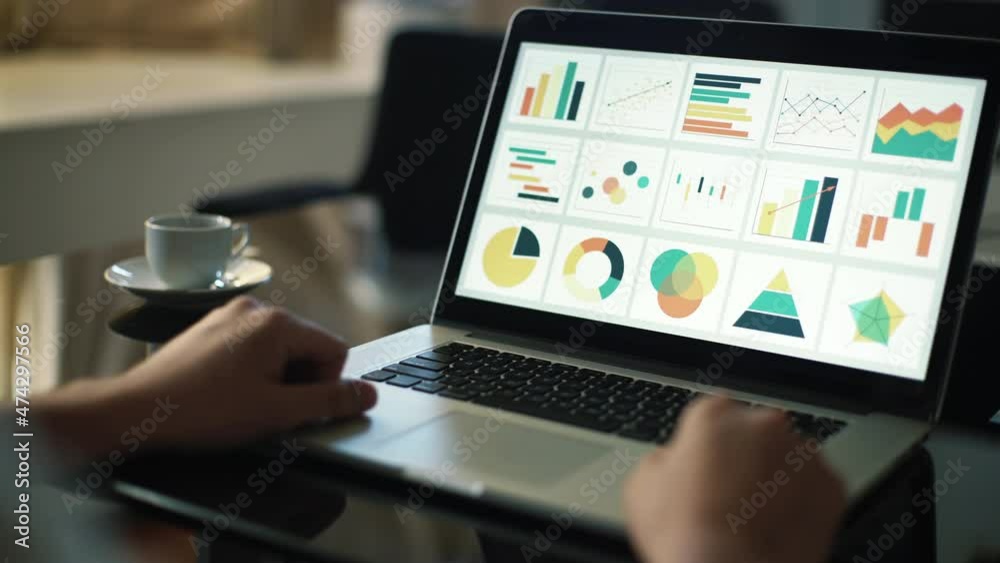 Businessman pointing or indicating infographic charts on the laptop ...