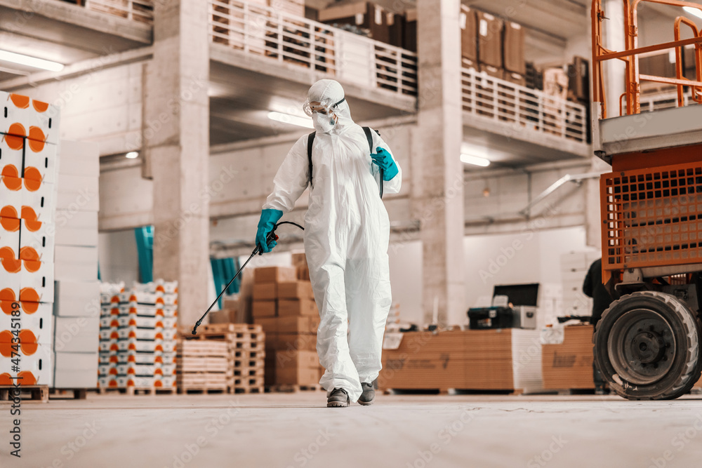 Person in a white protective suit refreshing and cleaning a public ...