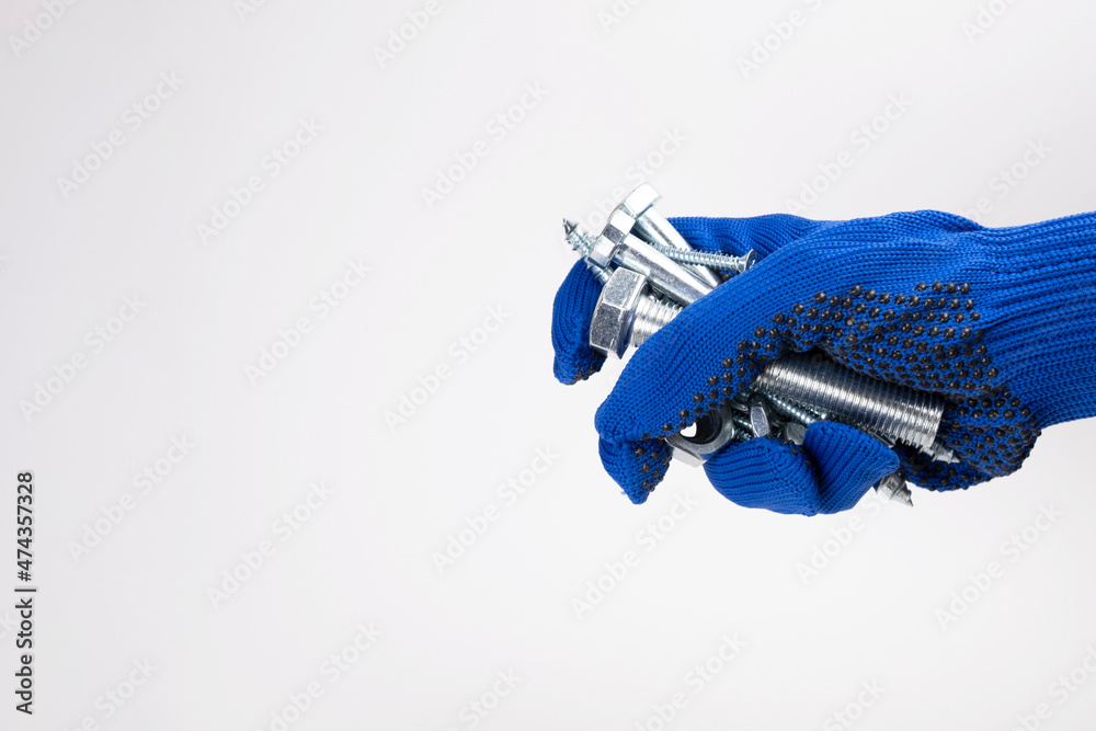 The hand clenches into a fist. Hand holds bolts, self-tapping screws on ...