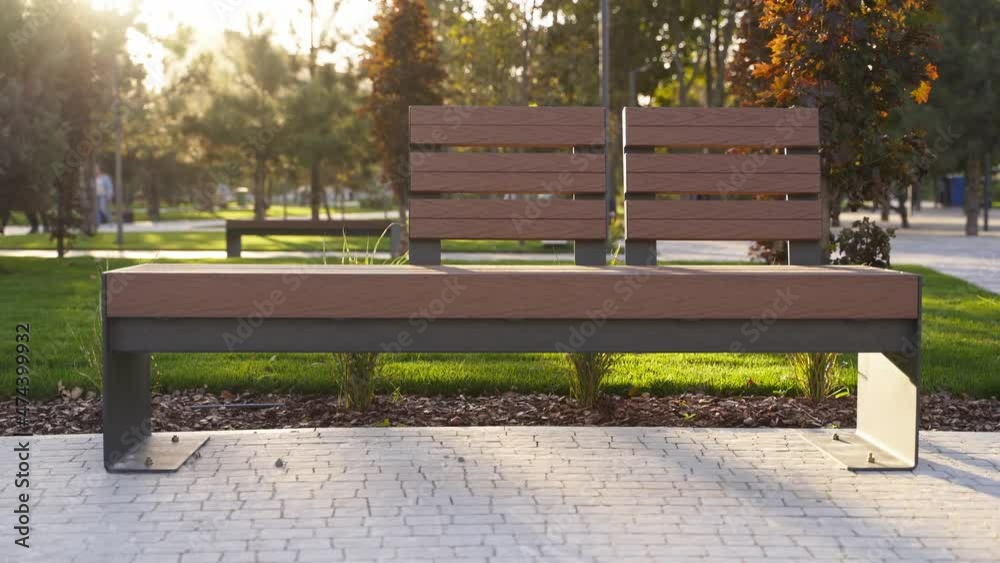 Modern wooden benches on the lawn in the park. Stylish new bench in ...