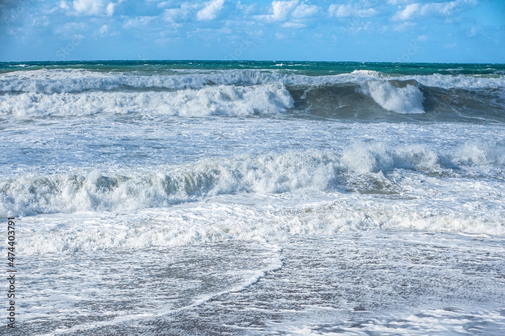 A strong November wind drives roaring waves to the shore, tearing white ...