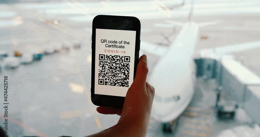 Passenger shows fake and non-active QR code in airport on screen of smartphone. Checking QR-code ...