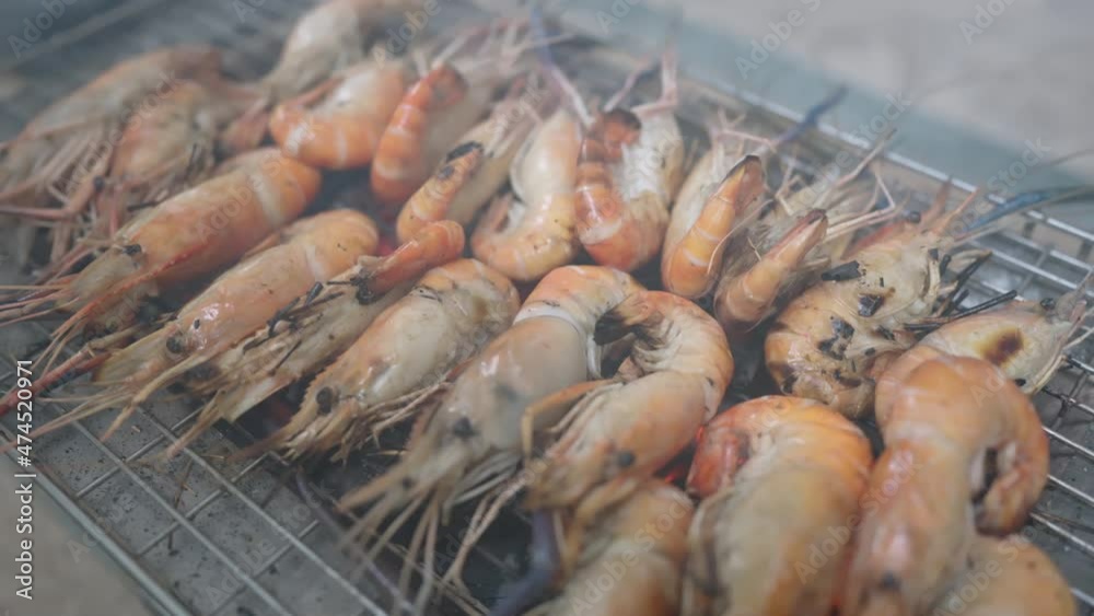4K, Big fresh prawns laying on the grill, being burned to turn orange ...