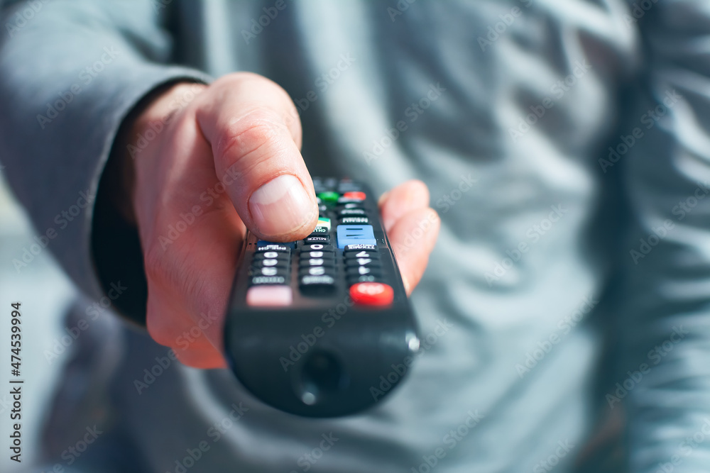 Man switches the TV channels.A hand with a remote control from the TV ...