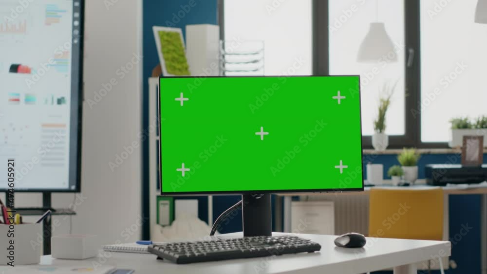 Close up of monitor with green screen at empty desk. Nobody in startup ...