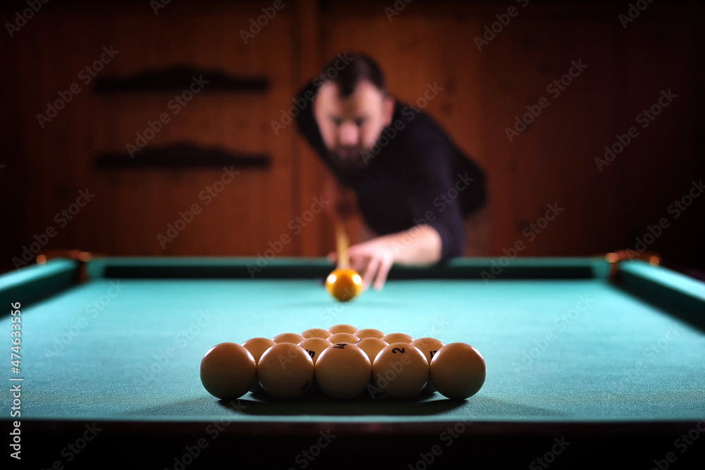 A man with a beard plays a big billiard. Party in a 12-foot pool ...