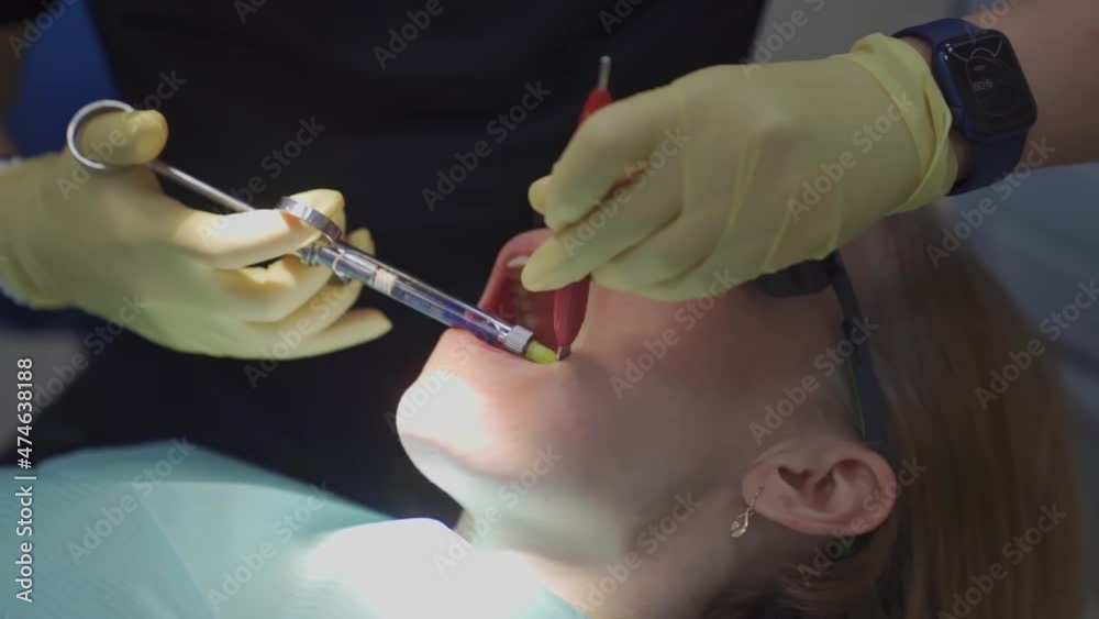 real. dentist injects an anesthetic into patient before tooth ...