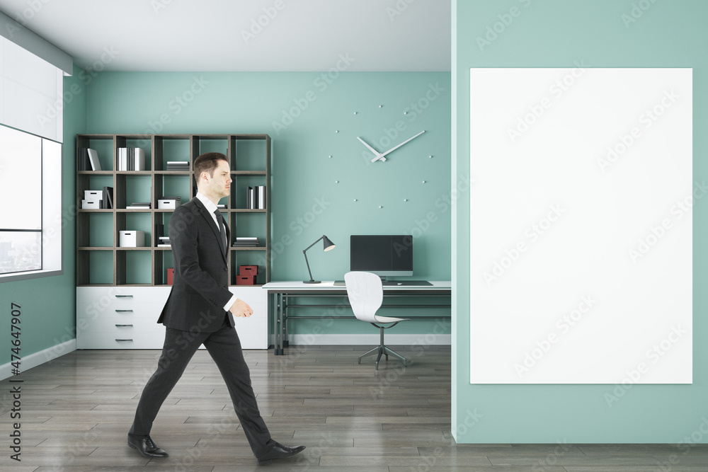 Businessman walking in modern blue office interior with empty mock up ...