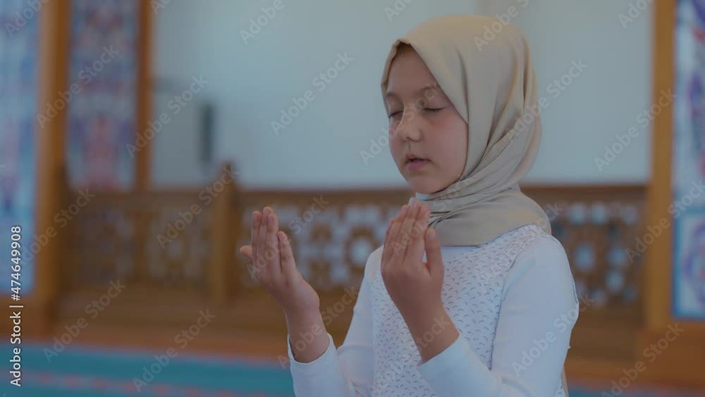 Little girl praying to god alone.Little girl dressed in hijab prays in ...