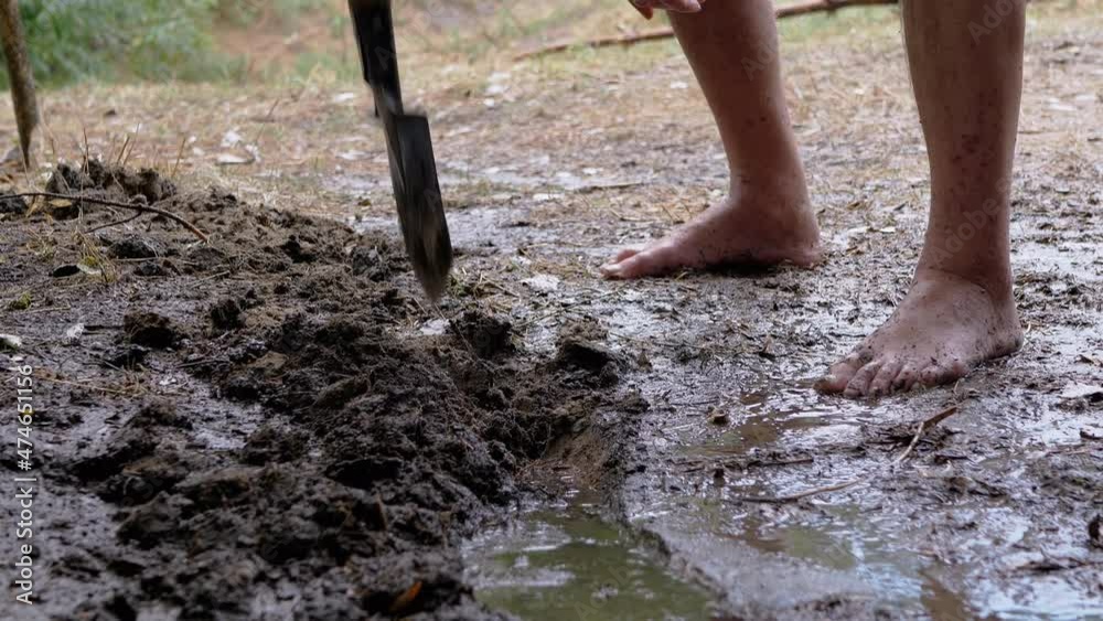 Human Digs a Storm Drain, a Trench, a Drainage in Wet Earth with using ...
