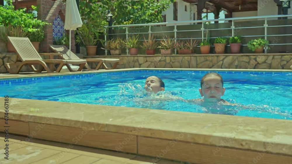 Little beautiful girls are swimming in the pool, playing in the water ...
