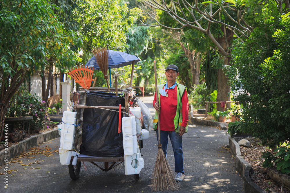 Portrait happy old Asian man street cleaner standing next to an old ...