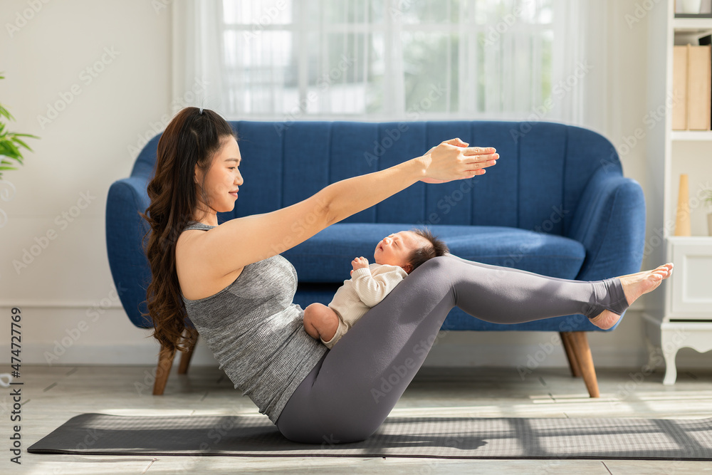 Side view of Wellness Asian woman mom doing yoga boat pose or navasana ...