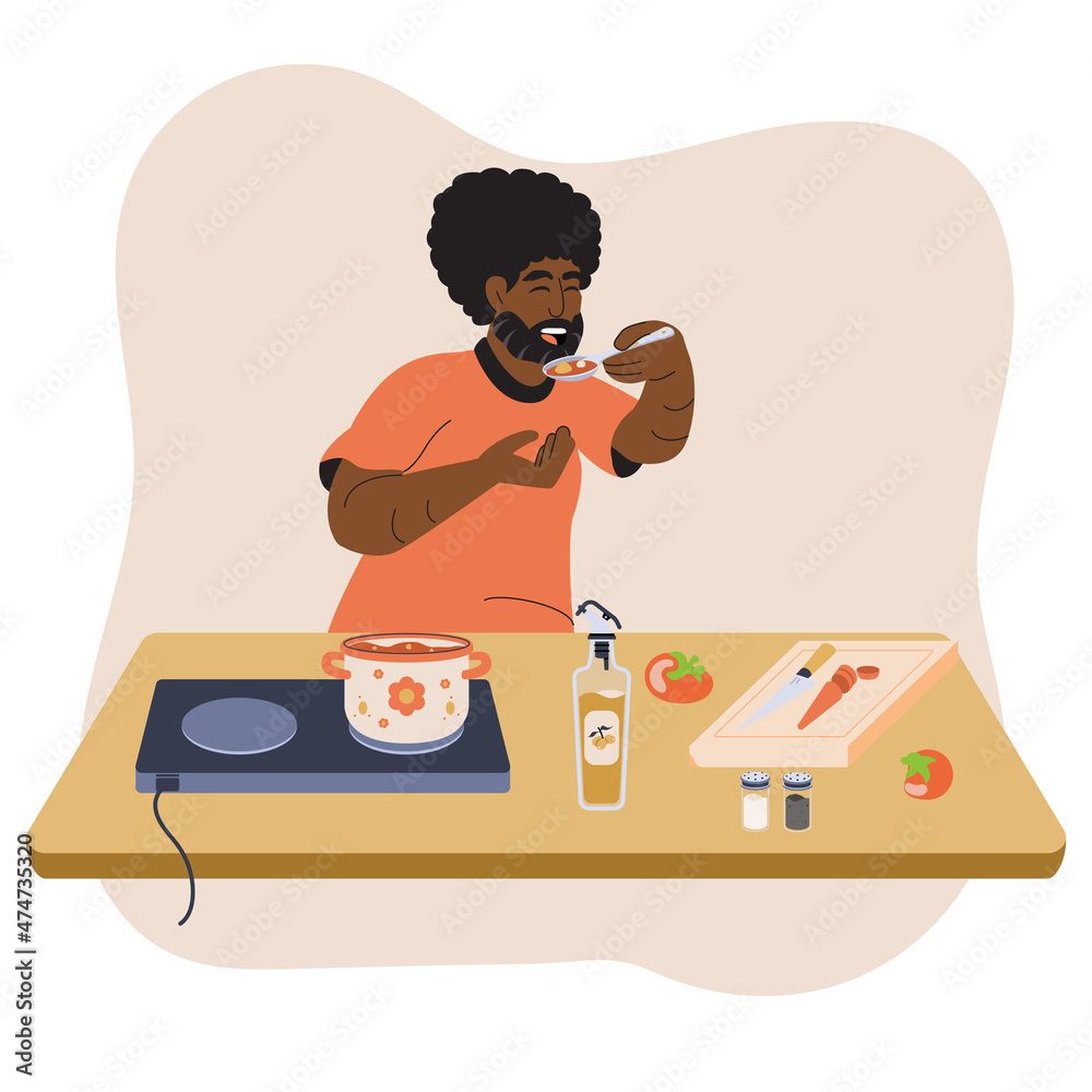 Man cooking in kitchen. Happy man tasting his cooking. Bearded chef ...