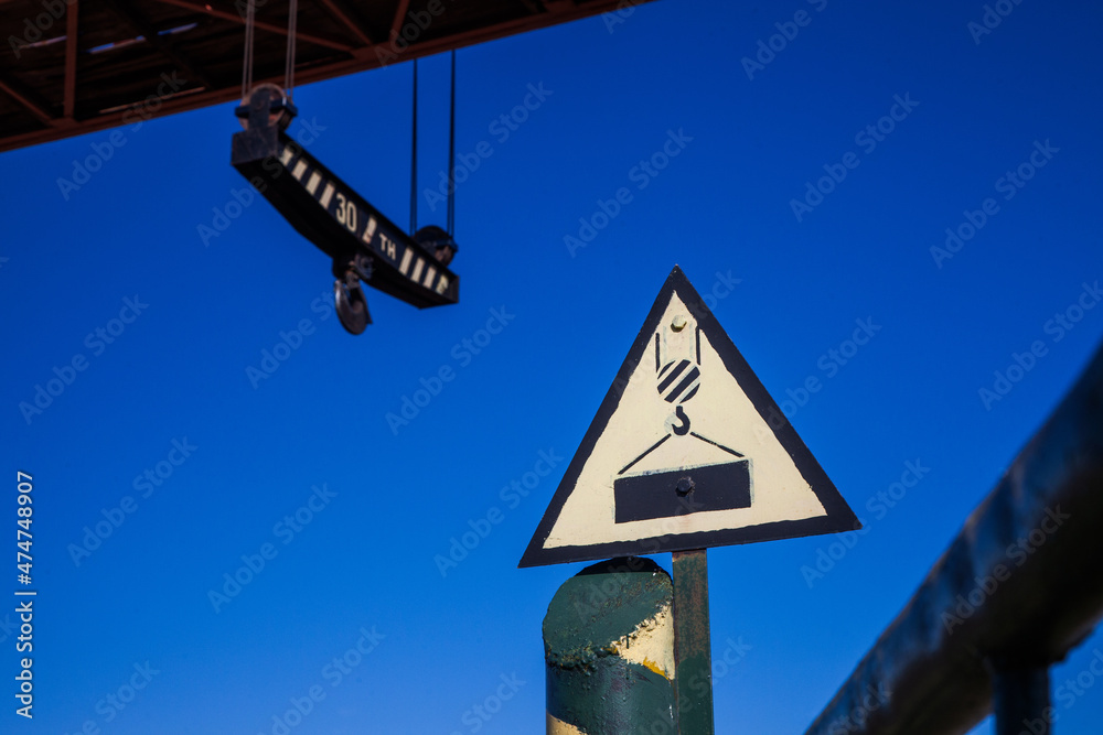 Self-made vintage warning road sign "Crane working" against deep blue ...