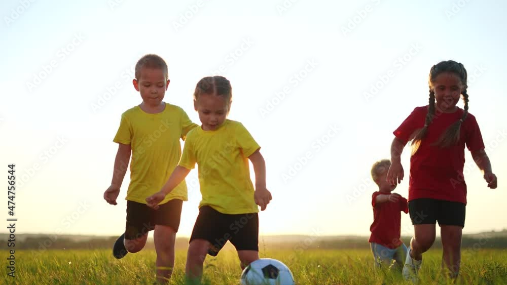 children playing ball in the park. sunlight happy family a kid run dream concept. children kick ...
