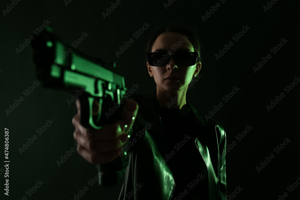 Woman with gun dressed in matrix style on dark background Stock Photo ...