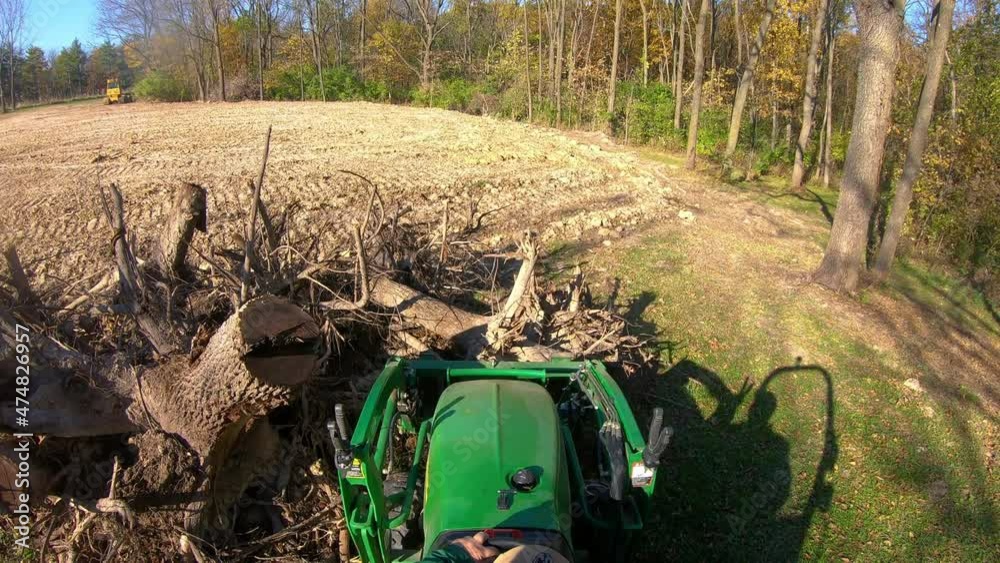 High angle point of view on small green tractor using lift forks to ...
