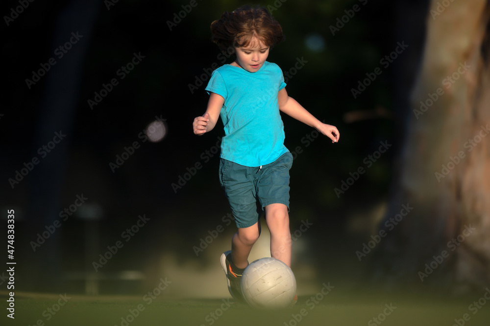 Fotka „Child playing football on the playground in park. Boy football ...
