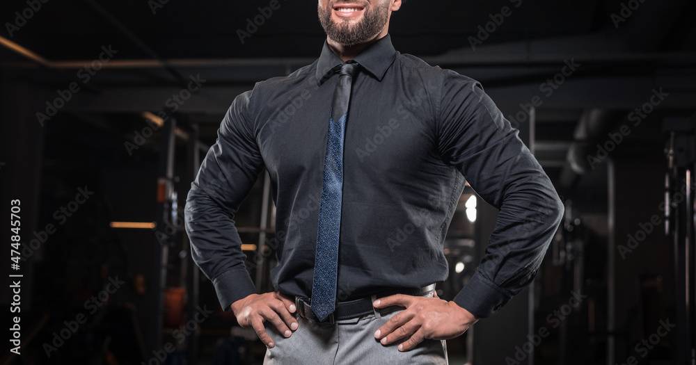 Image of a handsome muscular athlete in the gym. He poses in a black ...