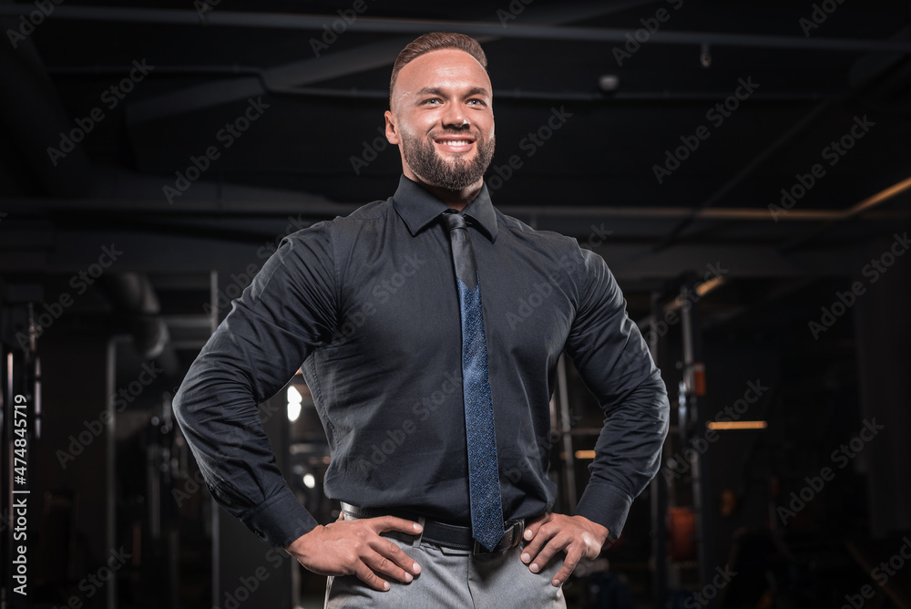 Image of a handsome muscular athlete in the gym. He poses in a black ...