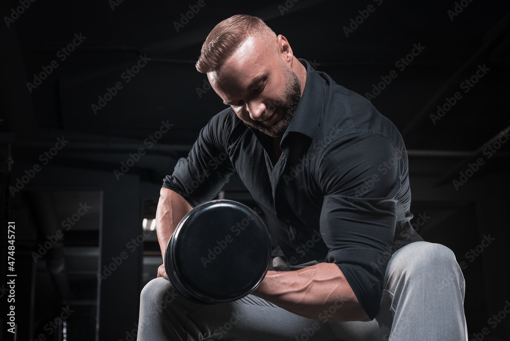Stylish man in a business suit works out in the gym. Business and ...