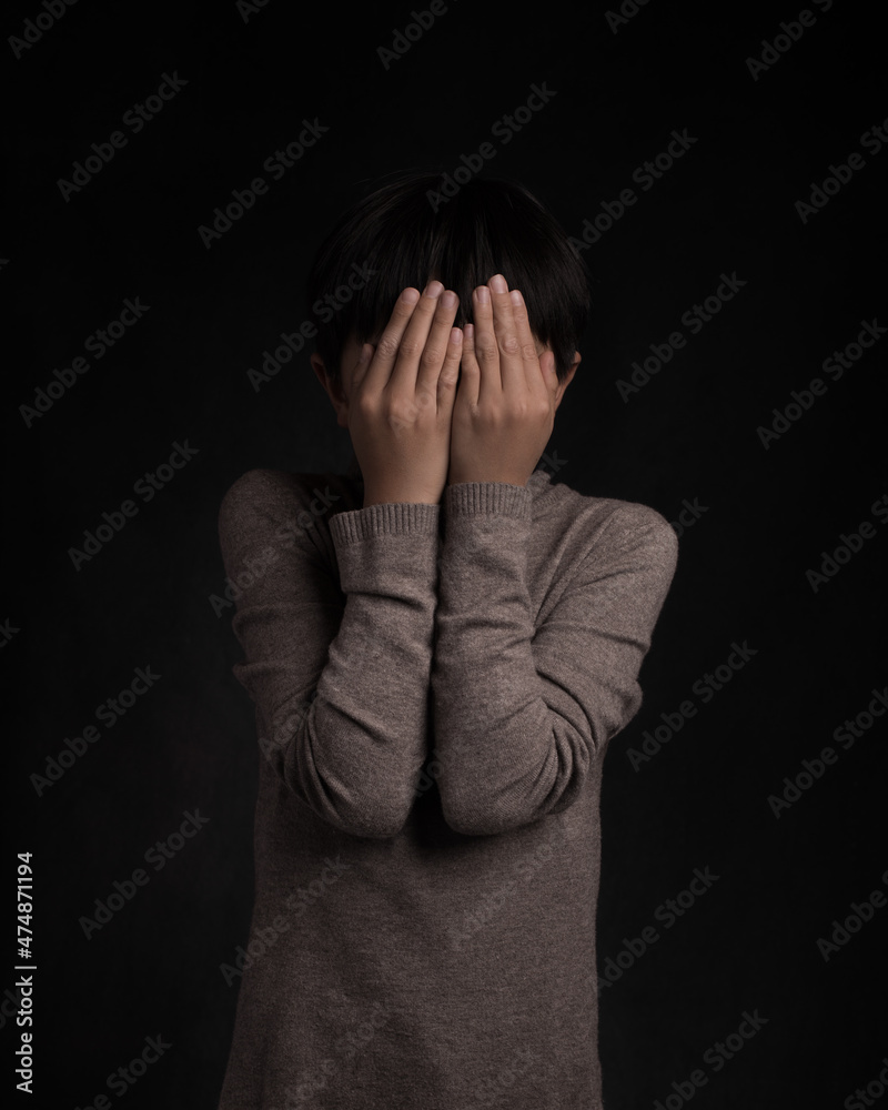 classic renaissance portrait of boy hiding behind his hands in front of ...