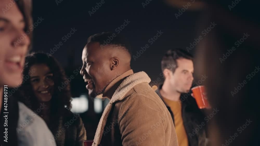 Black male happily socializing with a diverse group of friends on a ...