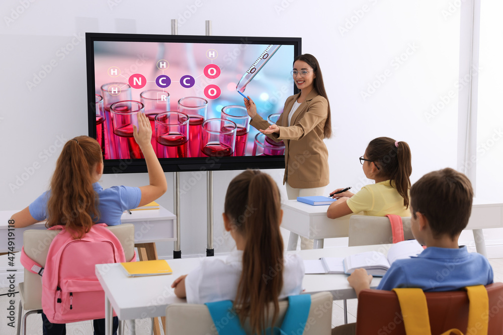 Teacher using interactive board in classroom during lesson Stock Photo ...