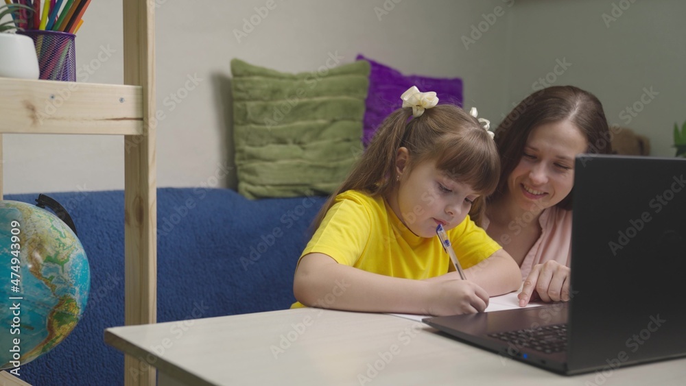 Foto Stock little child writes homework with a pen in a notebook, a kid ...