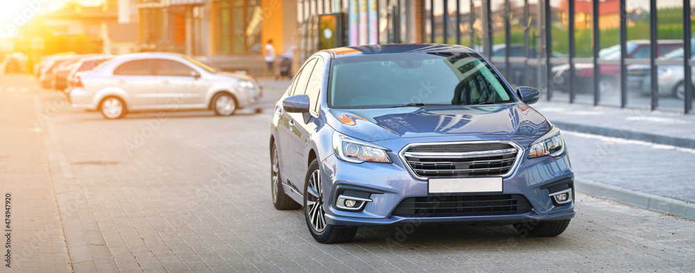 Panoramic view of new shiny expensive car parked on city street side ...