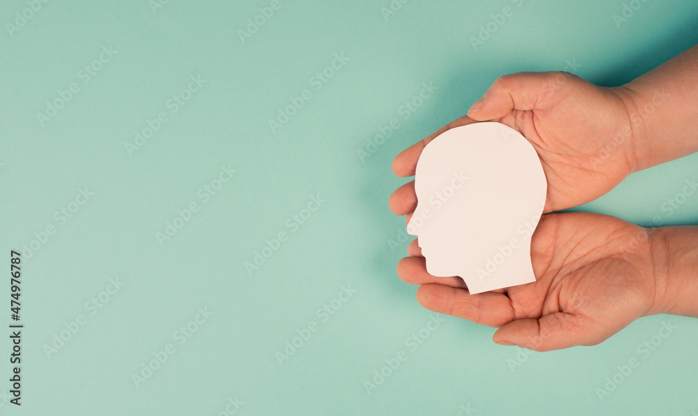 Holding a paper cut out head in the palms, symbolic for brainstorming ...