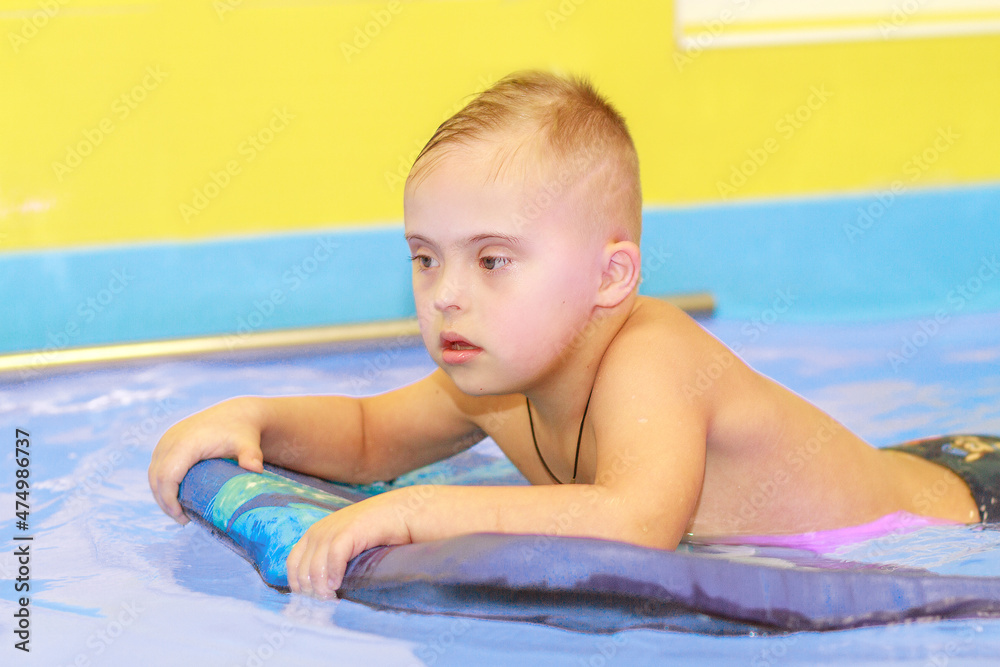 A boy with Down syndrome learns to swim in the pool, rehabilitation of ...