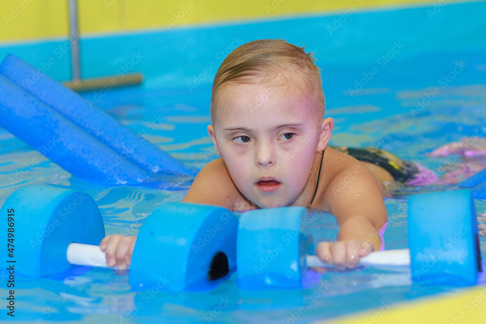A boy with Down syndrome learns to swim in the pool, rehabilitation of ...